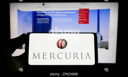 Person, die ein Smartphone mit einer Website des Handelsunternehmens ...