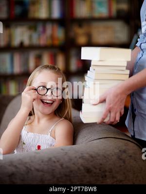Sie ist ein kleiner Bücherwurm. Ein süßes kleines blondes Mädchen, das lächelt, wenn jemand ihr ...