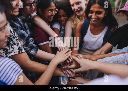 Multikulturelle Teenager, die ihre Hände in einem Zusammentreffen ...