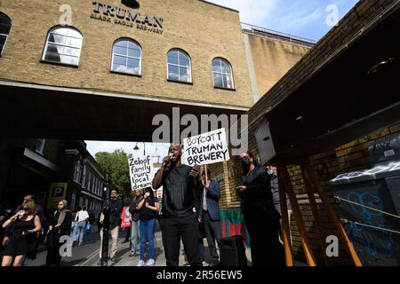 Ein Mitglied der Save Brick Lane Kampagne spricht bei einer Kundgebung ...