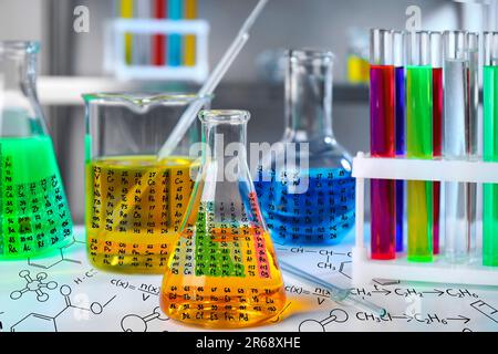 Verschiedene Glasgeräte mit Proben, Periodensystem der Elemente und ...