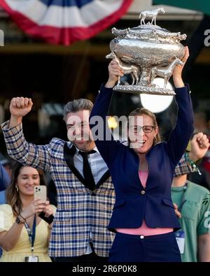 Trainer Jena Antonucci, left, hoists up the August Belmont Trophy ...