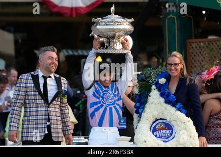 Trainer Jena Antonucci, left, hoists up the August Belmont Trophy ...