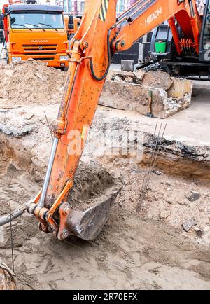 Der Bagger gräbt einen Graben zum Verlegen von Rohren und Kabeln ...
