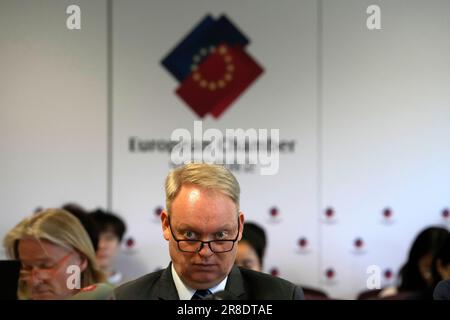 Jens Eskelund, President, European Chamber drinks from a cup at the ...