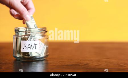 Sparen Sie Geld für einen Traum. Die Hand einer Frau steckt einen ...