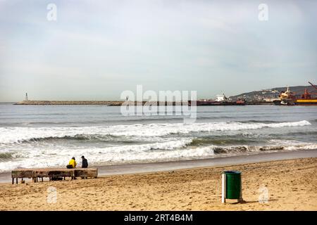 Ein wunderschöner Strand in Ensenada mit dem Hafen im Hintergrund und ...