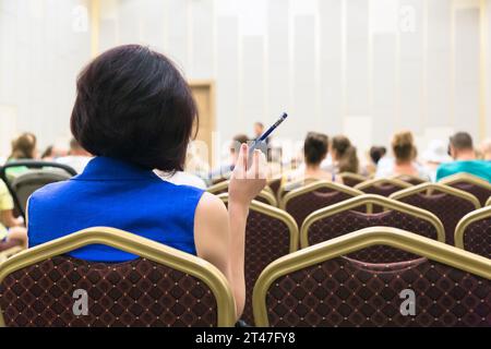 Eine Frau bei einer allgemeinen Sitzung des Unternehmensteams. Frau ...