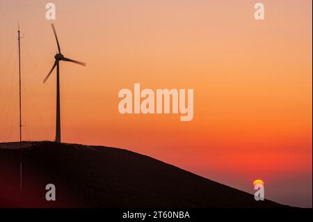 Eine Windturbine, die Teil eines Windparks ist, nutzt den Wind, um Energie zu erzeugen, wenn die ...