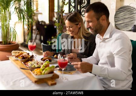 Ein junges Paar beim Mittagessen und beim Trinken von frisch gepresstem ...