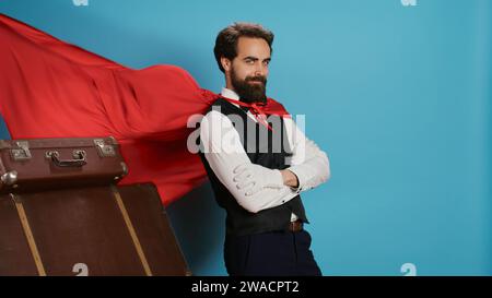 Hotelpagen, der mit cape als Superhuman fungiert, bieten Personen mit ...