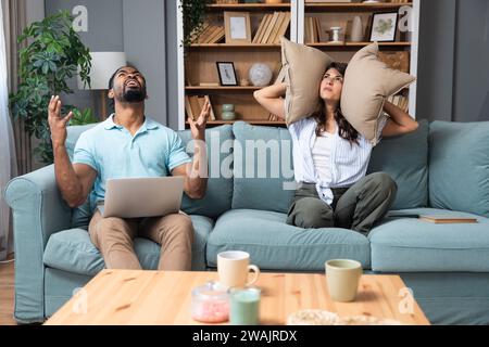 Ein junges Paar starrt an die Decke und schreit, weil ein Nachbar oben ...