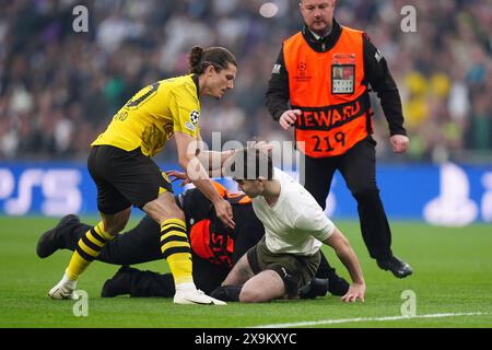 Ein Eindringling auf dem Spielfeld wird von Borussia Dortmunds Marcel ...