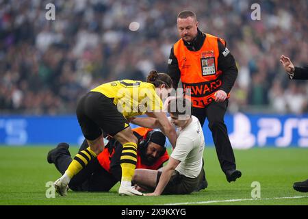 Ein Eindringling auf dem Spielfeld wird von Borussia Dortmunds Marcel ...