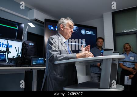 09. August 2024, Nordrhein-Westfalen, Münster: Ein Polizeibeamter steht vor einem Monitor mit ...