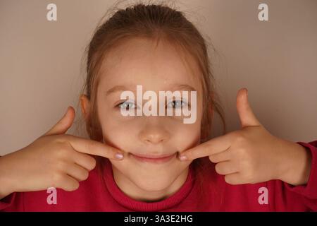 Das Mädchen legt sanft ihre Finger auf ihre Lippen, was ein Gefühl von ...