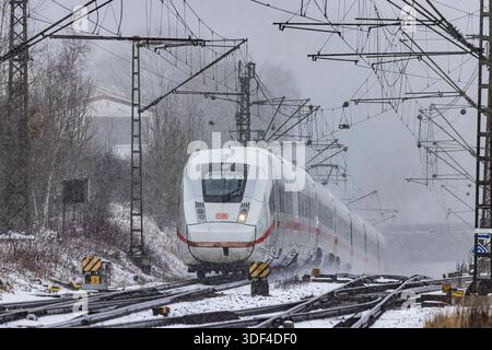 ICE unterwegs bei Schneefall durch eine Winterlandschaft. Ein Zug auf ...