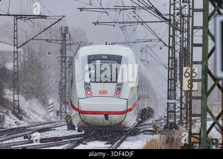 ICE unterwegs bei Schneefall durch eine Winterlandschaft. Ein Zug auf ...