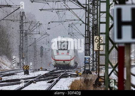 ICE unterwegs bei Schneefall durch eine Winterlandschaft. Ein Zug auf ...