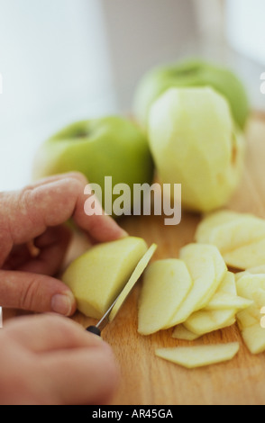 APPLE WIRD IN SCHEIBEN GESCHNITTEN MIT MESSER AUF HÖLZERNEN ...