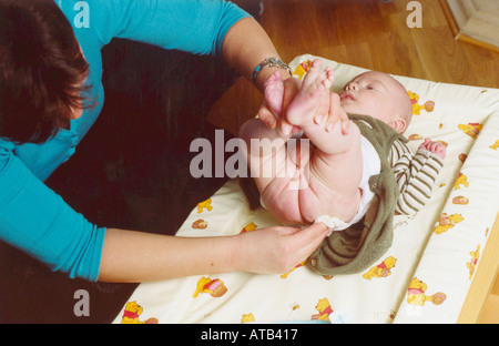 Mutter ändern windel baby, ihre kleinen Beine anheben Stockfoto, Bild ...