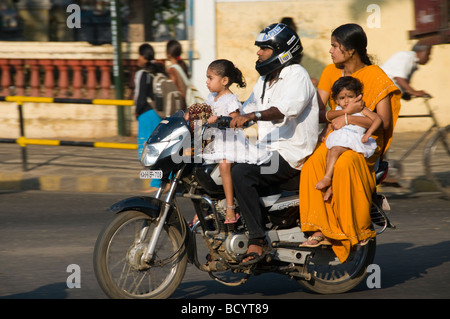 Indische Familie auf einem Motorrad mit Regenschirm Reiten durch nassen ...