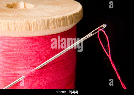 Spool-roter Faden und Nadel ausgeschnitten auf weißem Hintergrund ...