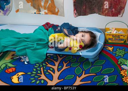 4 Jahre alte Kindergarten Mädchen liegend auf einem Feldbett während ...