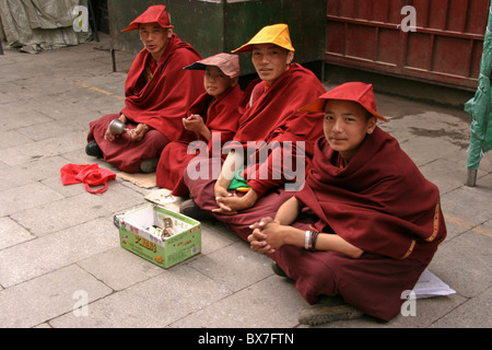Junge tibetische buddhistische Mönche tragen orangefarbene Gewänder Fuß ...