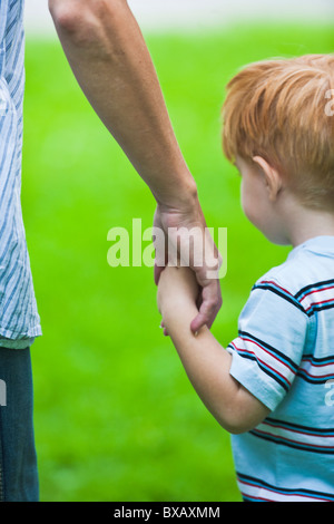 Vater hält die Hand des Jungen in Winterkleidung, Winter, Familie, Hand ...