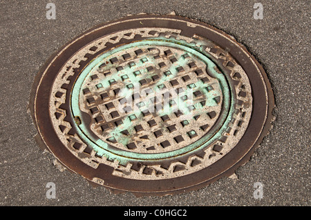 Runde Stahl Kanalisation Kanaldeckel auf gepflasterten Straße Stockfoto ...
