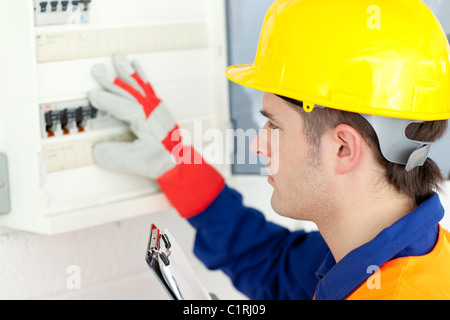 Schöne fröhliche Elektriker Instandsetzung der Box und mit einem ...