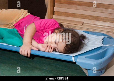 4 Jahre alte Kindergarten Mädchen schläft auf einem Feldbett während ...