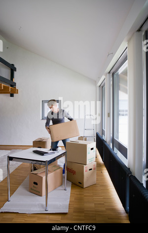 Pappkartons mit Gegenständen und Möbeln im Büroinnern am Umzugstag ...