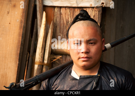 Eine junge basha Miao Mann (Gun Männer) mit traditionellen Frisur und ...