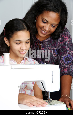 Mutter einer interrassischen Familie, die zu Hause mit einem Computer ...