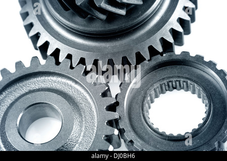 Drei Zahnräder aus Metall, die auf einem zentralen roten Rad auf weißem ...