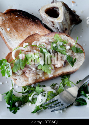 Gebratenes Knochenmark serviert mit Toast und Petersilie und Zwiebeln ...