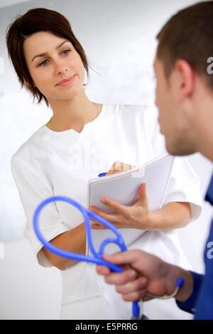 Arzthelferin erhält Anweisungen des Arztes, die sie unterstützt ...