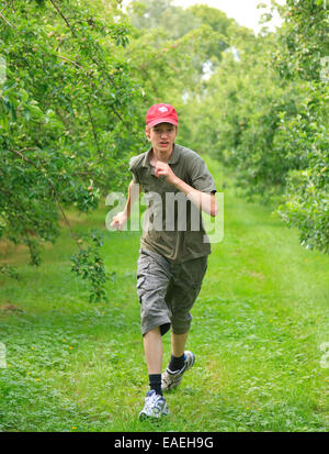 Teenager junge 15 Jahre alt läuft im Apfelgarten Stockfotografie - Alamy