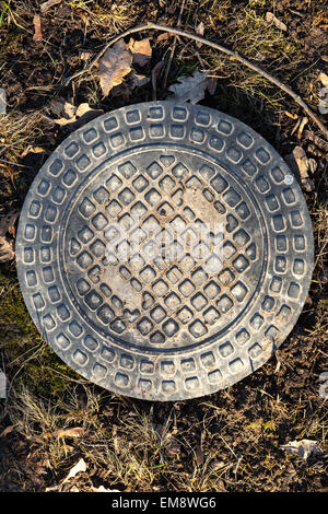 Runde Stahl Kanalisation Kanaldeckel auf gepflasterten Straße Stockfoto ...