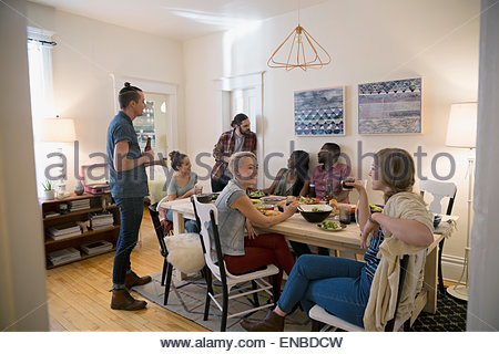 Freunde rund um einen Tisch, Männer und Frauen lachen und Klirren ...