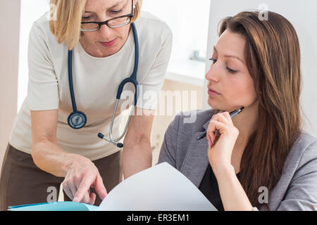 Arzthelferin erhält Anweisungen des Arztes, die sie unterstützt ...