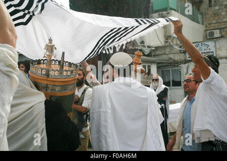 Eine neue Tora-Rolle wird in eine Synagoge gebracht, während die ...