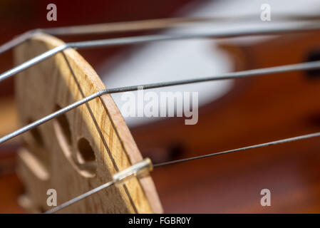 Eine braune Geige mit vier Saiten und Violine Bogen auf weißem ...