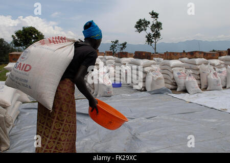 Frau trägt einen großen Sack Mais, der von USAID am WFP ...
