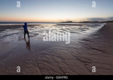 Die Sonne geht über Dunstanburgh Castle, Embleton Bay in Northumberland ...