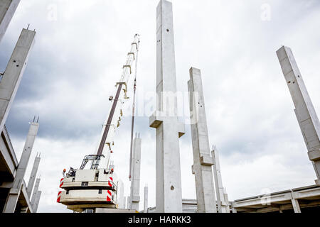 Mobiler Kran ist an Montage Beton Balken auf neue Gebäude in Betrieb ...