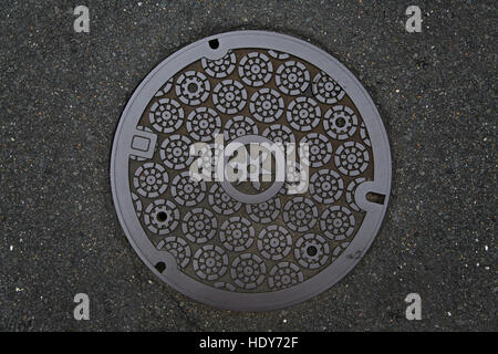 Runde Stahl Kanalisation Kanaldeckel auf gepflasterten Straße ...