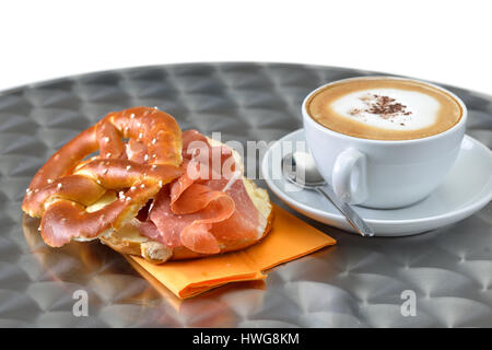 Kleines Frühstück: Butter Brezel mit Parmaschinken und einer Tasse ...